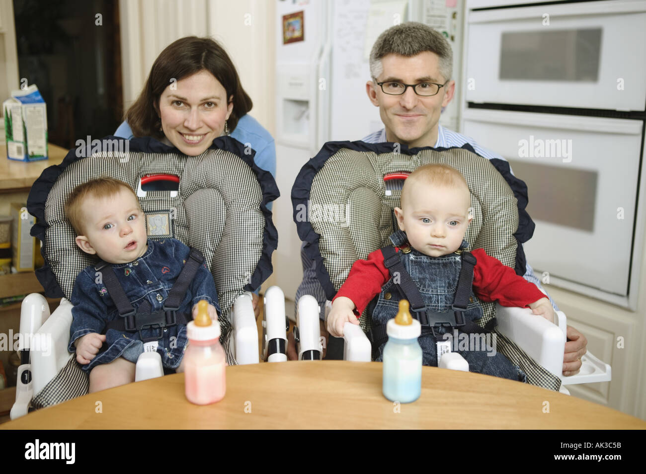 Parents with their twin babies Stock Photo - Alamy
