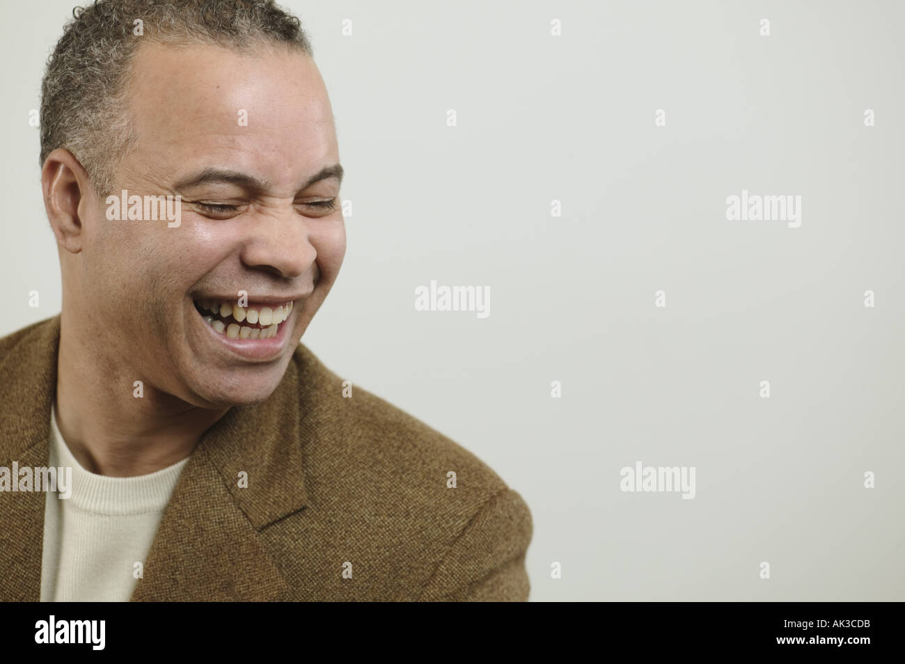 Studio portrait of a man laughing Stock Photo - Alamy