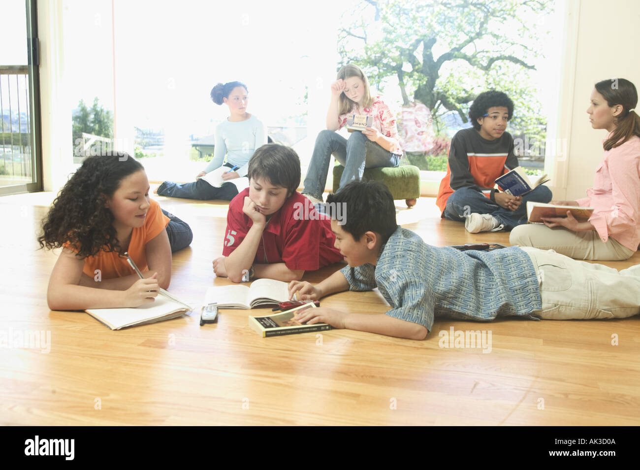 Teenage girls and boys lying on the floor and doing homework Stock ...