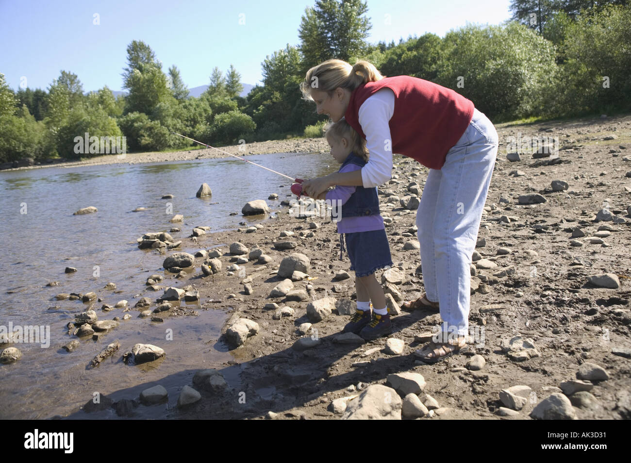 Mother helping her daughter fish Stock Photo - Alamy