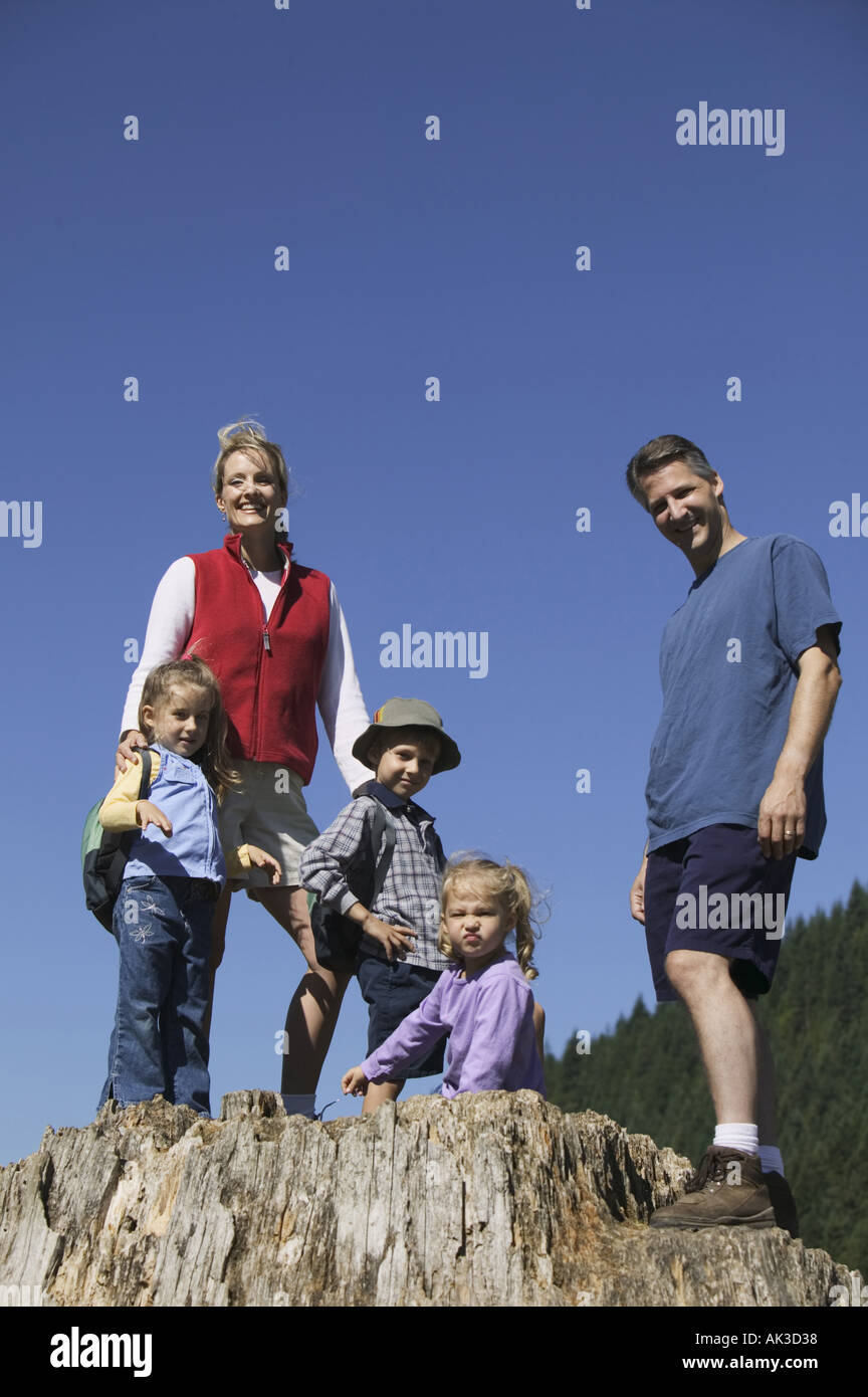 Smiling family on tree stump hi-res stock photography and images - Alamy