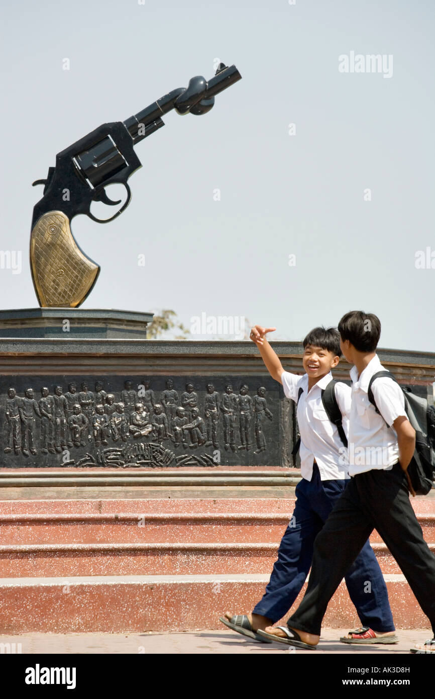 Friends walk past knotted gun monument, Phnom Penh, Cambodia Stock ...