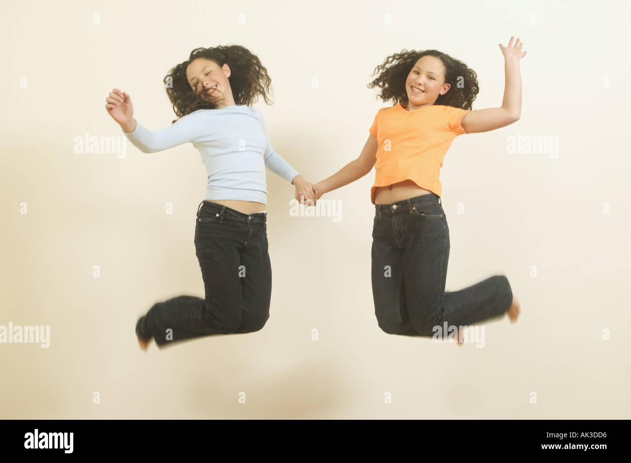 Twin teenage girls leaping in the air Stock Photo - Alamy