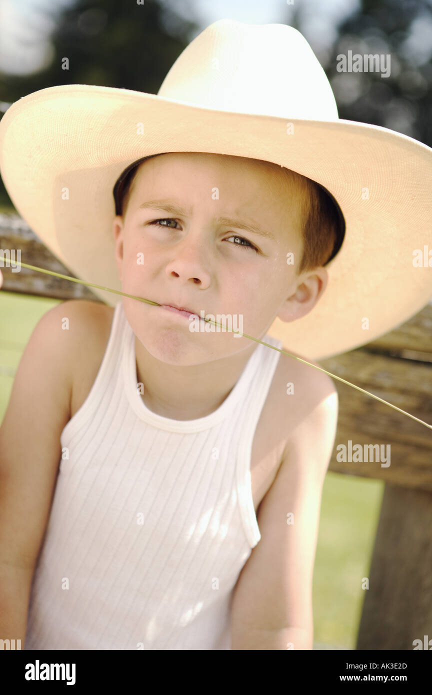 Boy wearing a cowboy hat and chewing on grass Stock Photo - Alamy