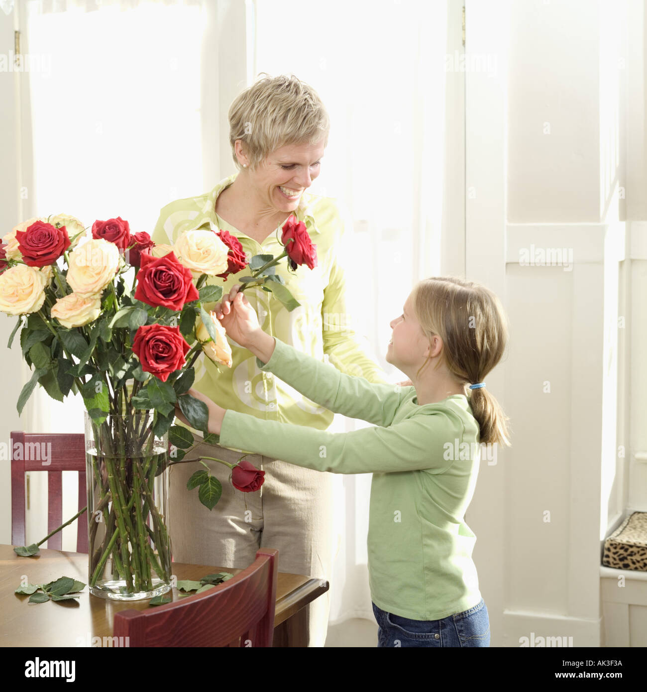 Mother arranging roses with her daughter Stock Photo - Alamy