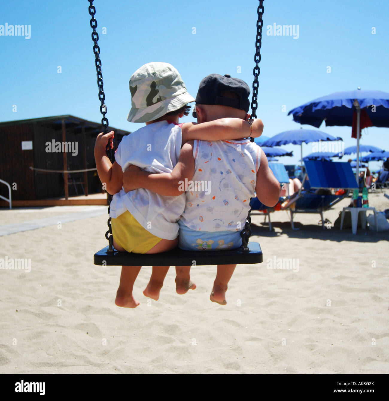 two children together on a swing hug one another Stock Photo - Alamy