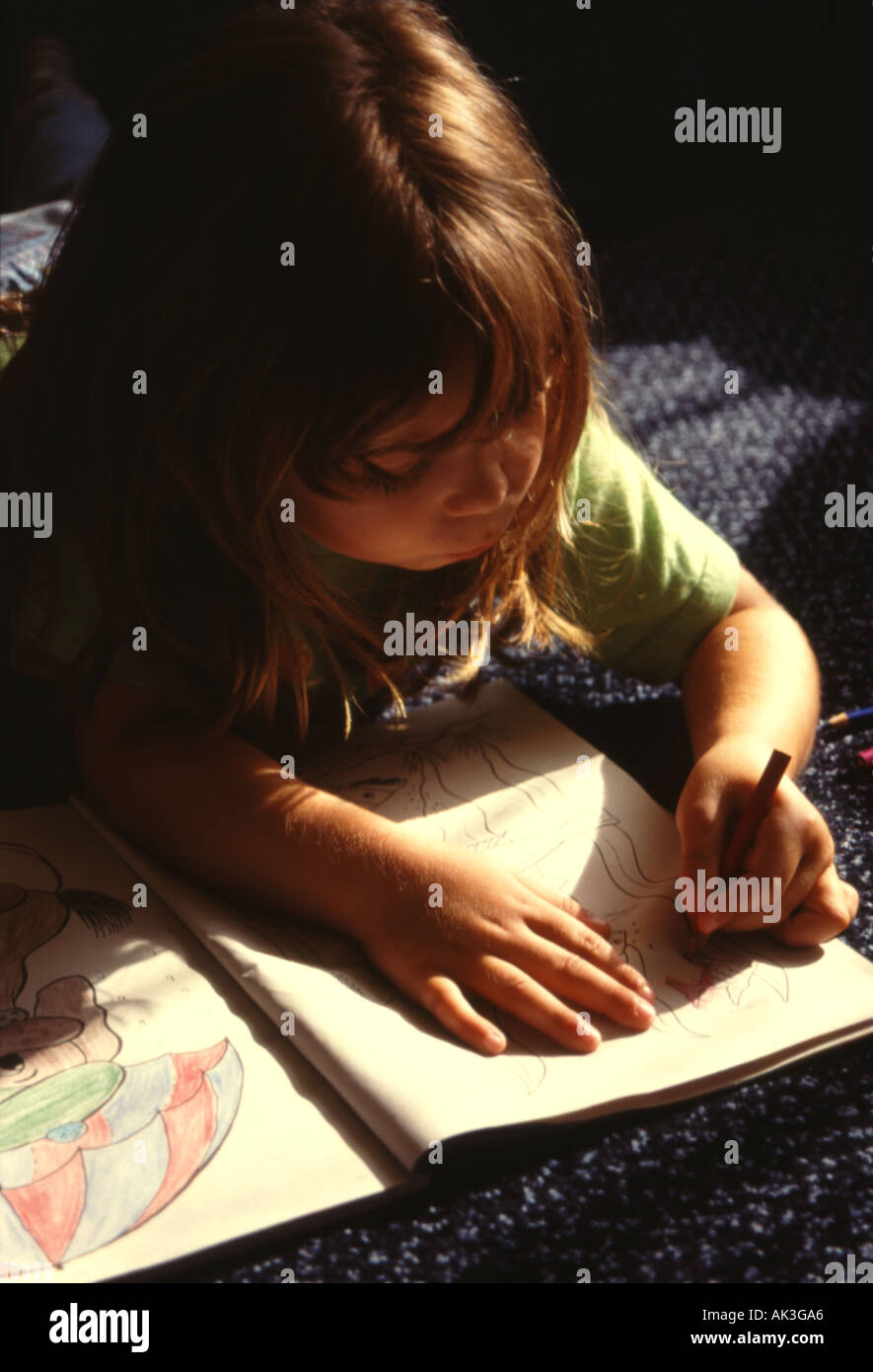Model released shot of a young left handed girl colouring in a picture ...