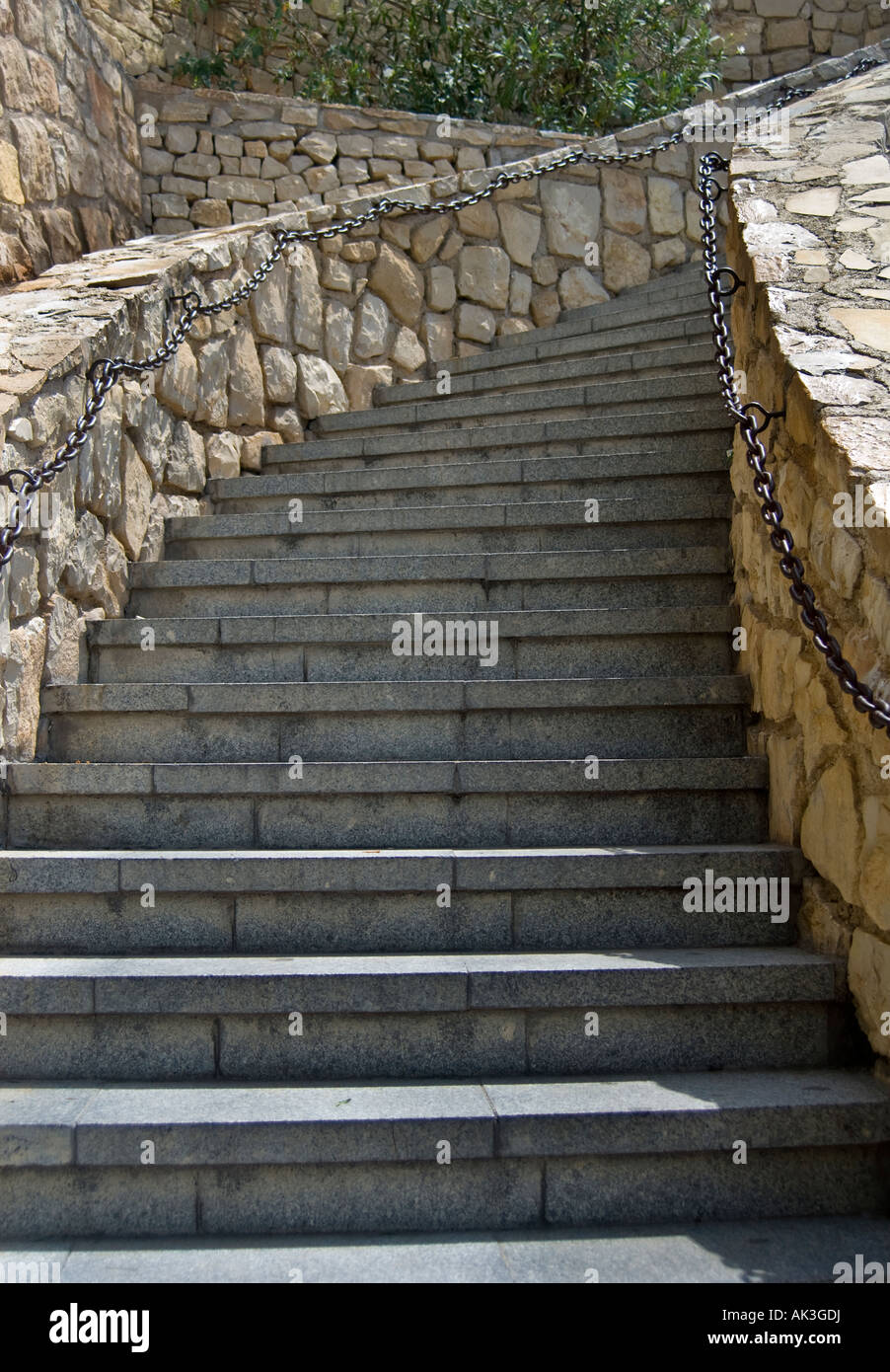 Ascending stone steps and walls with chain hand rail Stock Photo - Alamy
