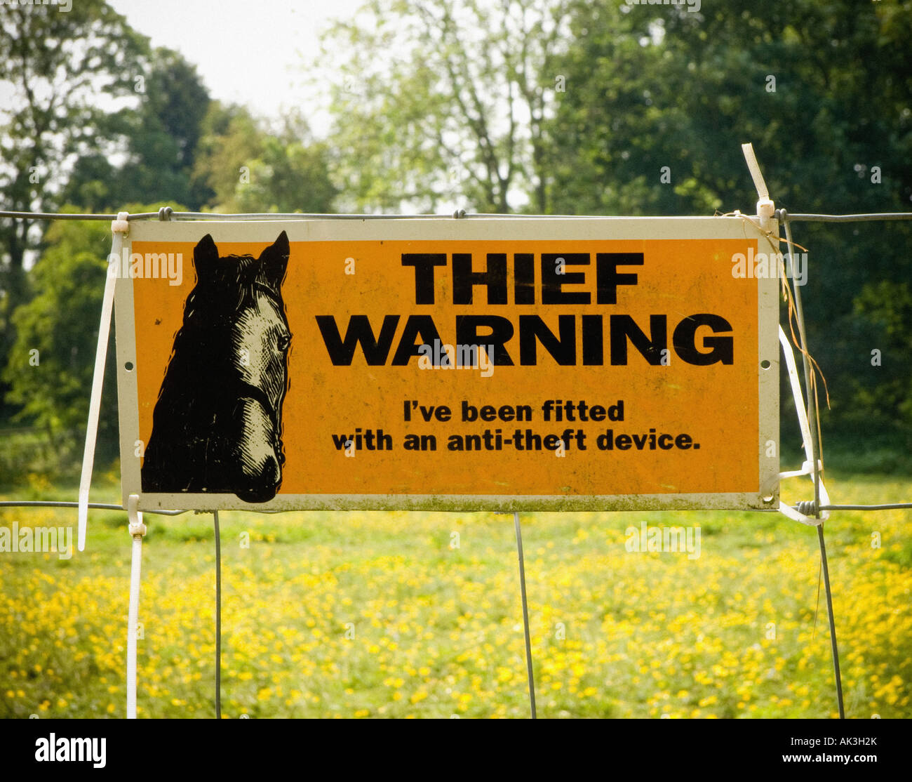 Warning sign for horse thieves attached to a wire fence on the edge of ...