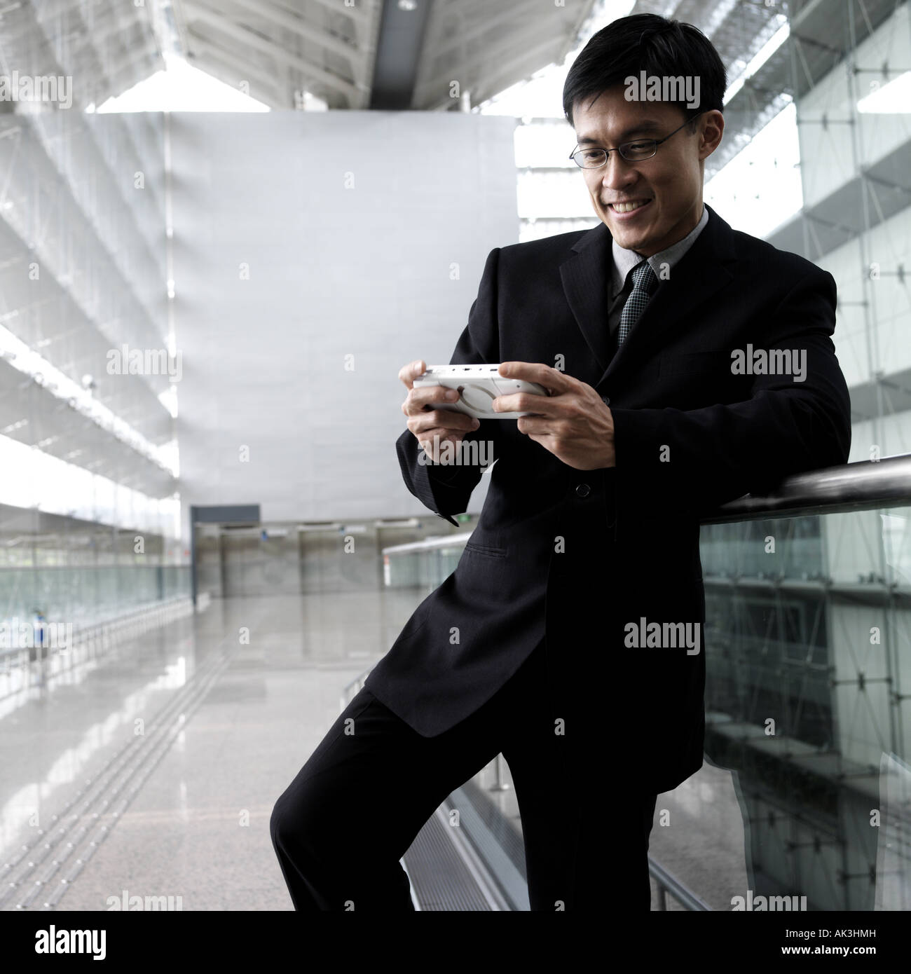 Businessman playing handheld video game Stock Photo - Alamy