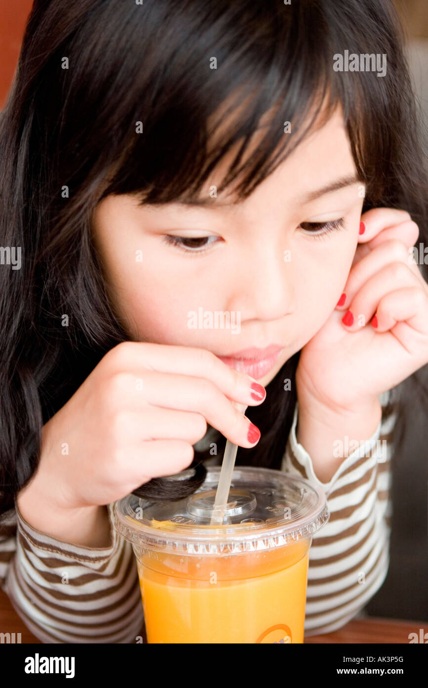 Girl CHILD 5 6 sipping through straw close up Stock Photo - Alamy