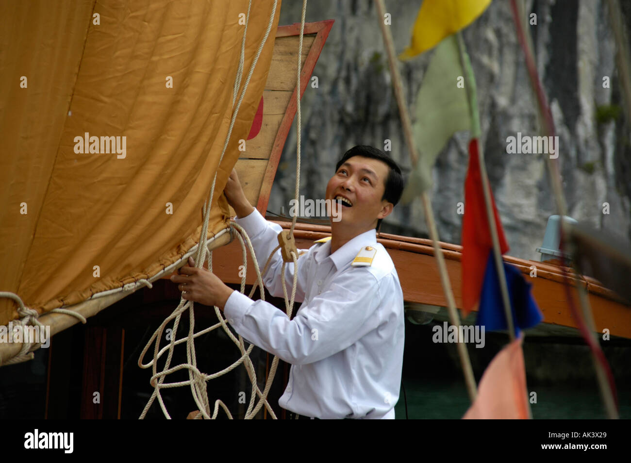 Captain of a traditional sailing ship is setting sail Ha Long Bay ...