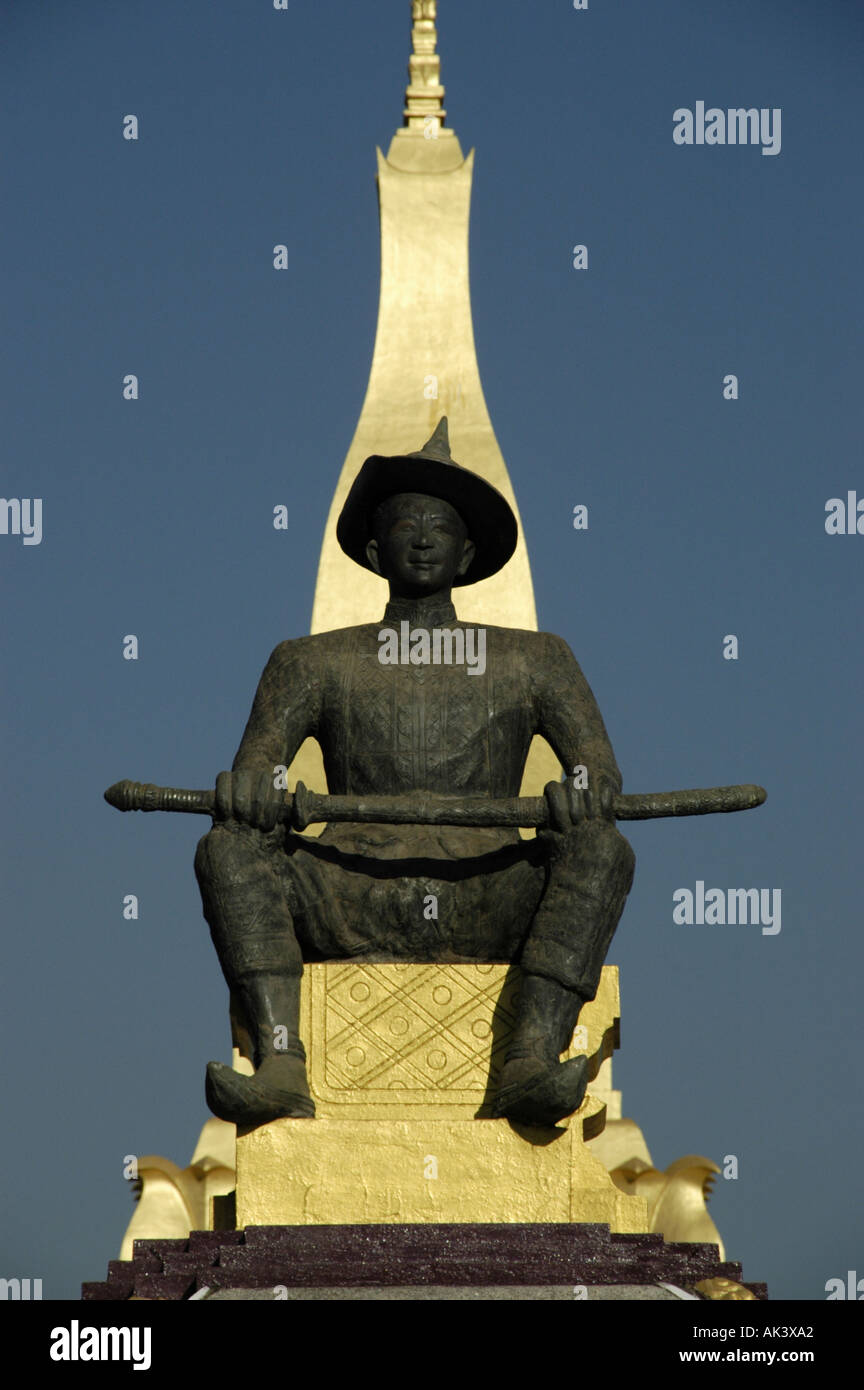 Statue of king Setthathirat sitting in front of the golden temple Wat ...