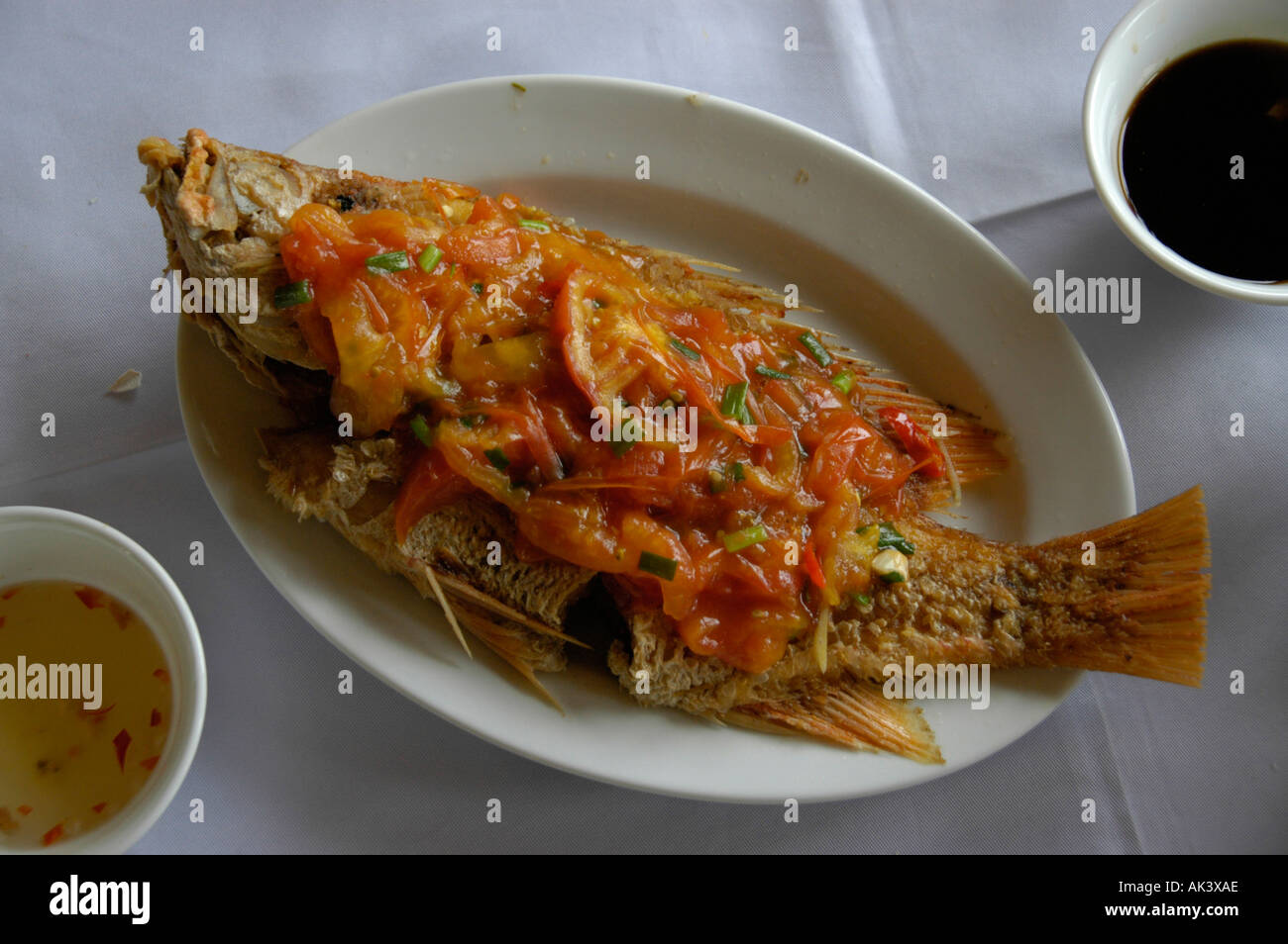 Grilled fish with tomato cream on a plate served on a sail ship in the ...