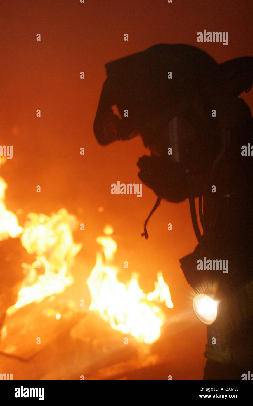 A fire fighter in a room on fire doing a search and rescue Stock Photo ...