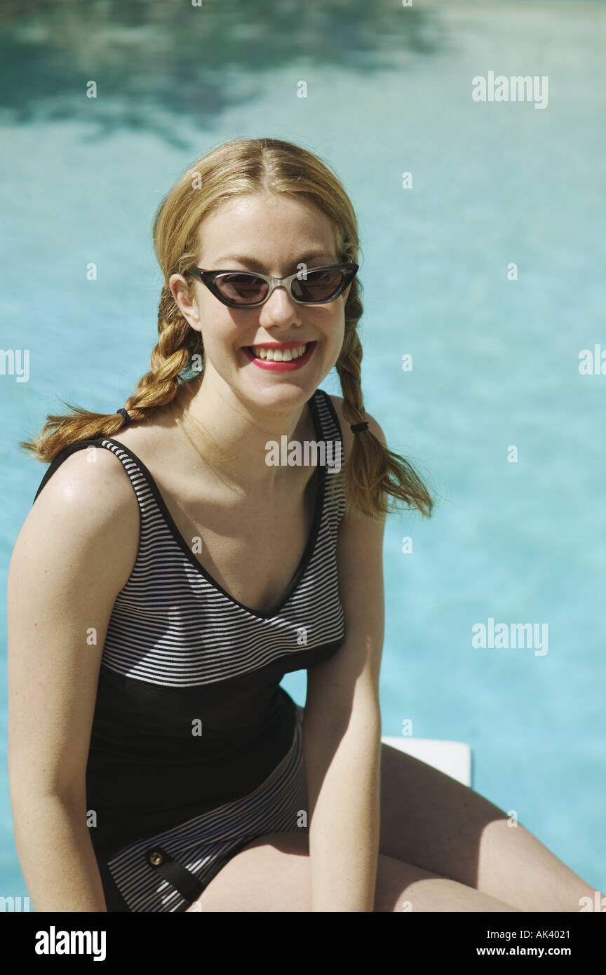 Young woman sitting on a diving board Stock Photo - Alamy