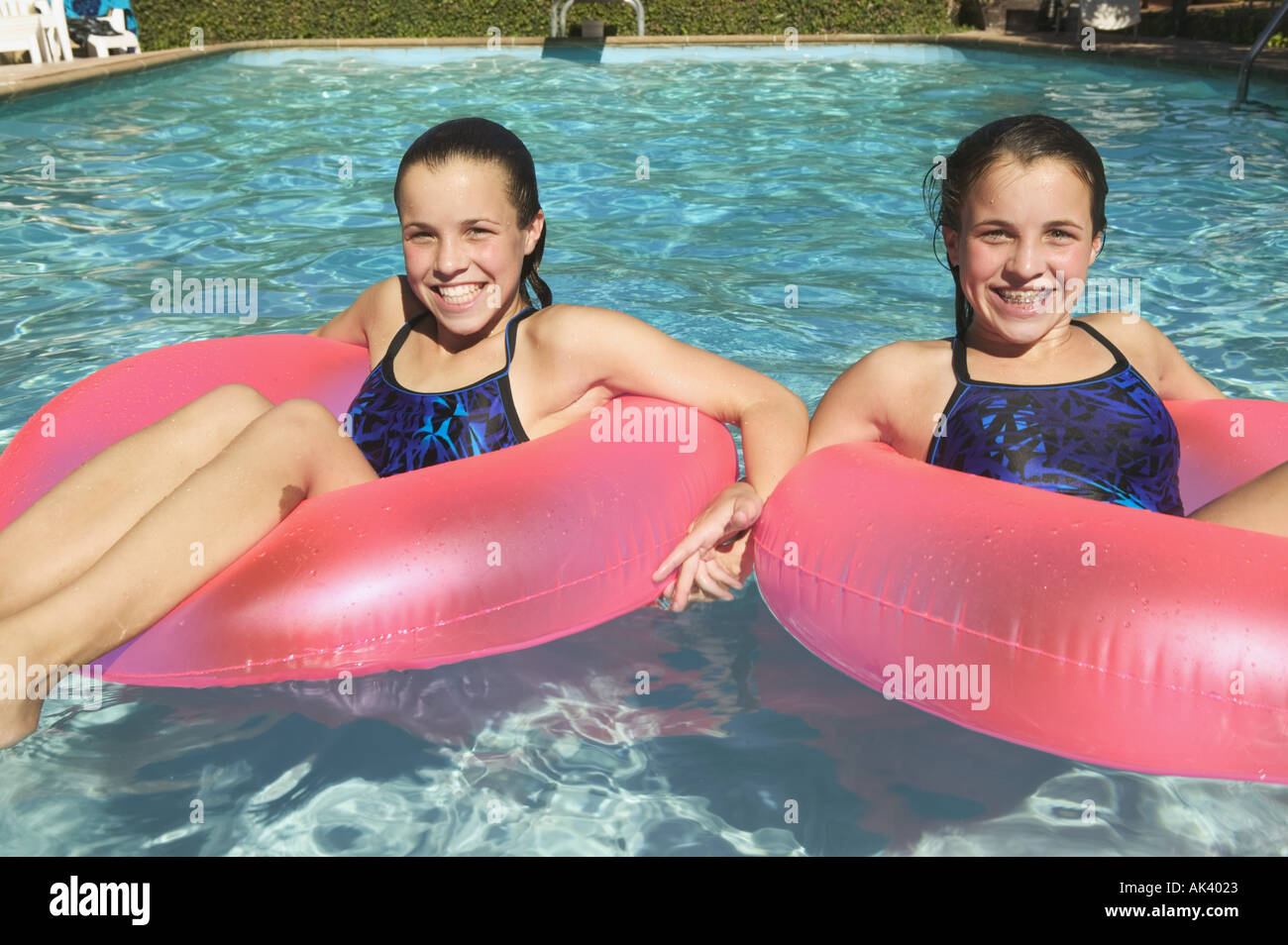 Twin teen girls in a pool Stock Photo - Alamy