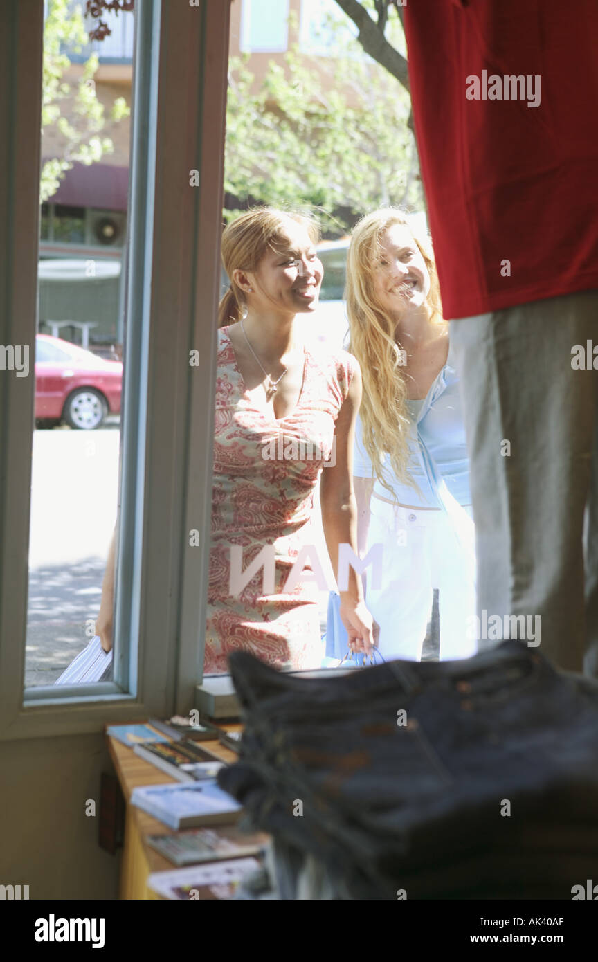 Two young women window shopping outside a boutique Stock Photo - Alamy