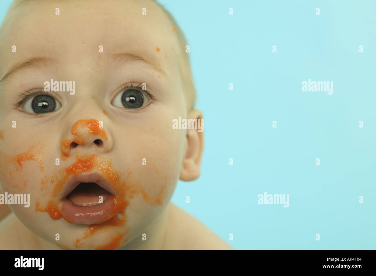 A baby with his face smeared with baby food Stock Photo - Alamy