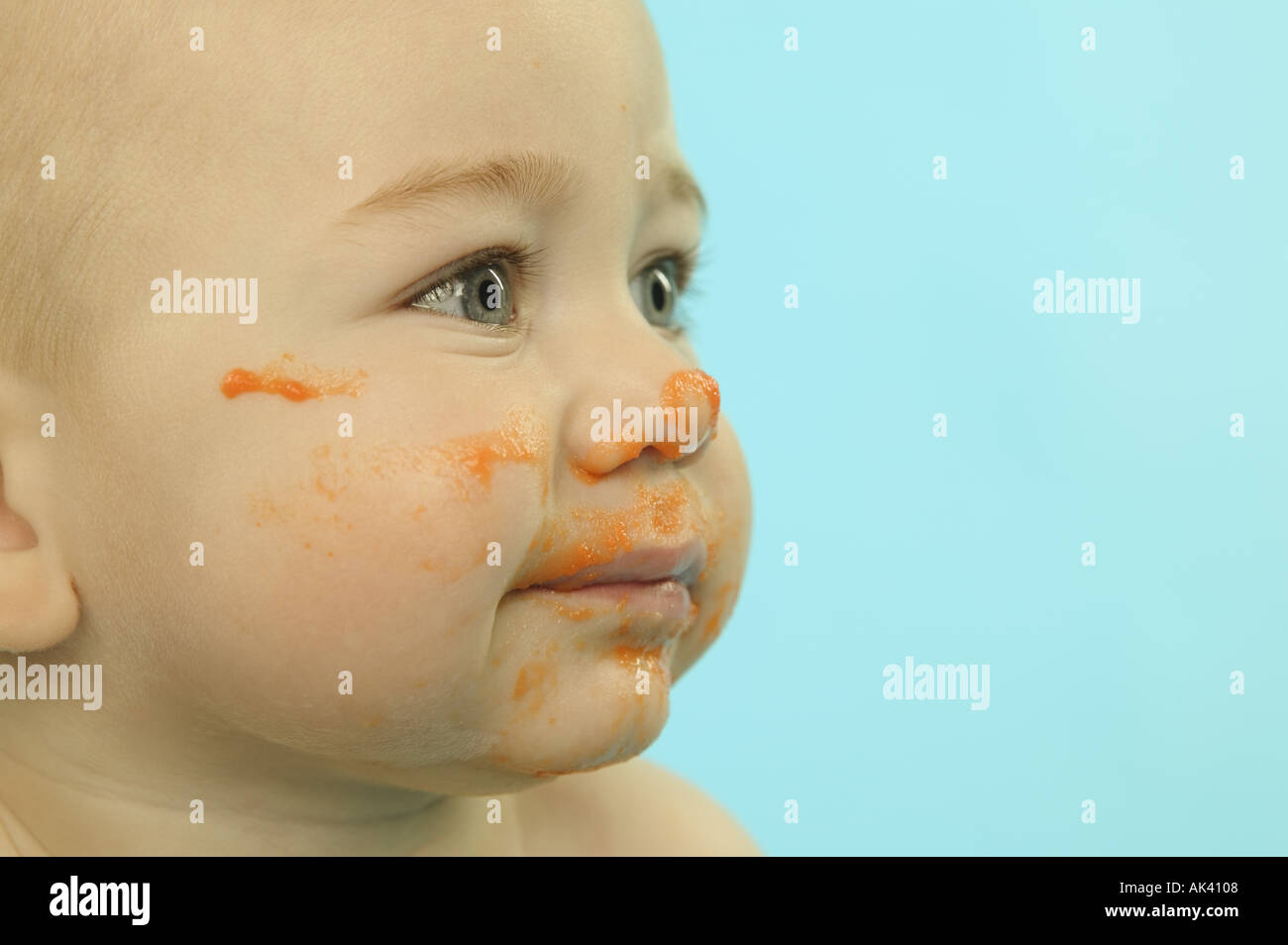 A baby with his face smeared with baby food Stock Photo - Alamy