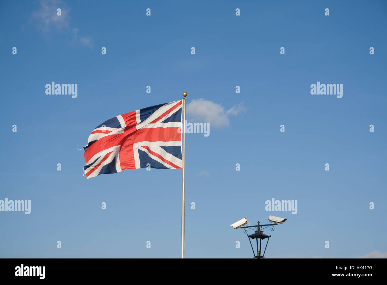 Large Union Jack fluttering next to a pair of security cameras against ...