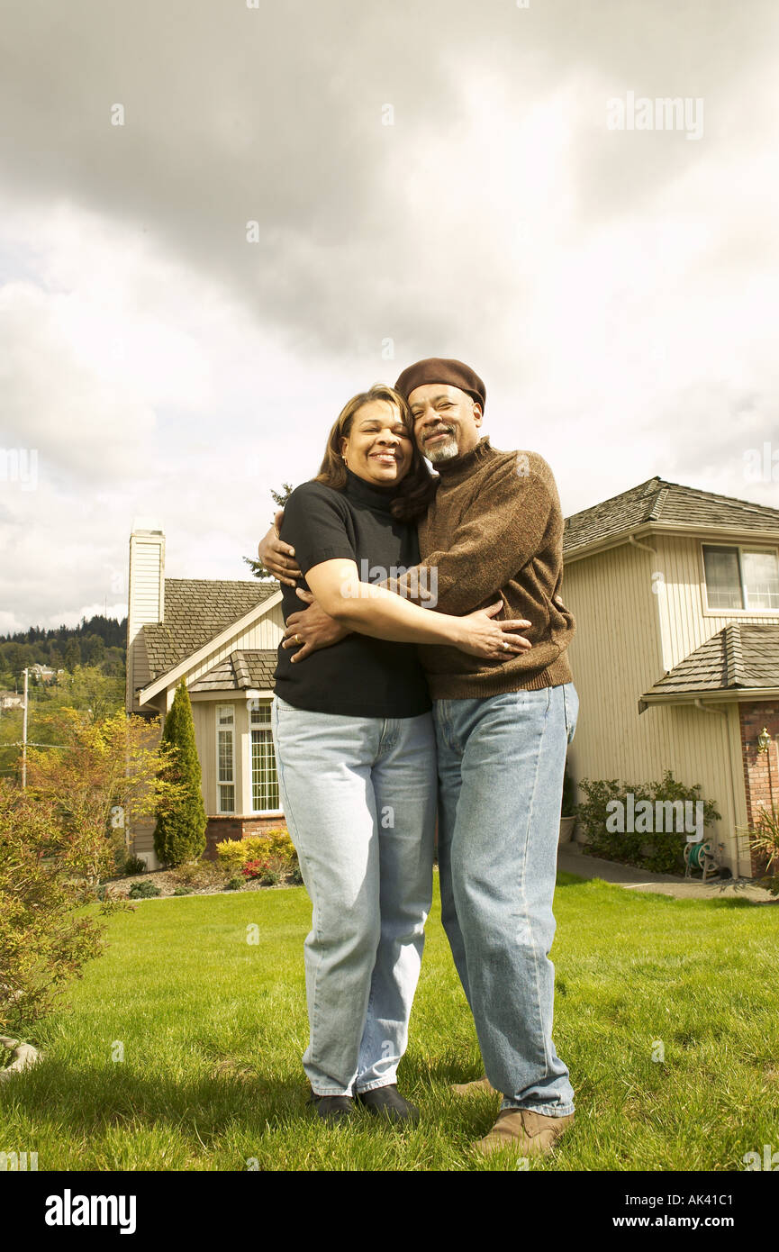 A couple hugging in front of their home Stock Photo - Alamy