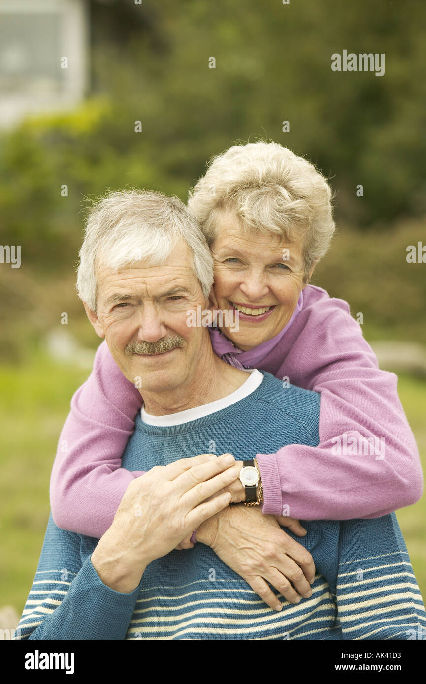 A woman with her arms wrapped around her husband Stock Photo - Alamy