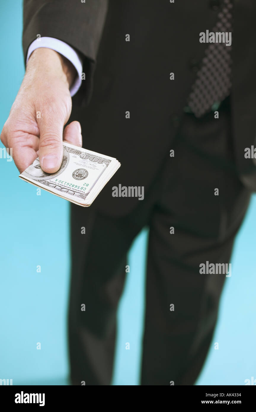 A man in a suit offering money Stock Photo - Alamy