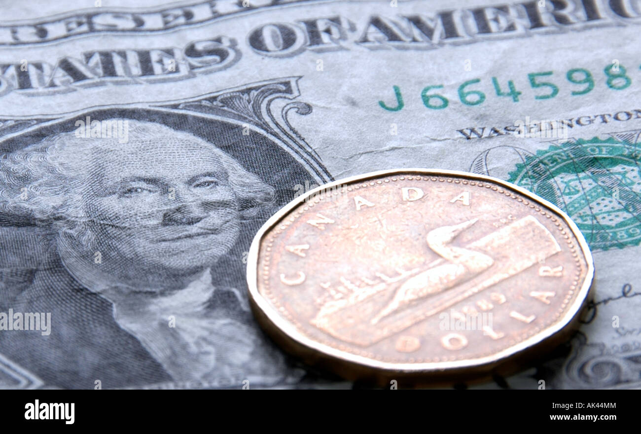 Canadian dollar coin on top of US dollar bill Stock Photo - Alamy