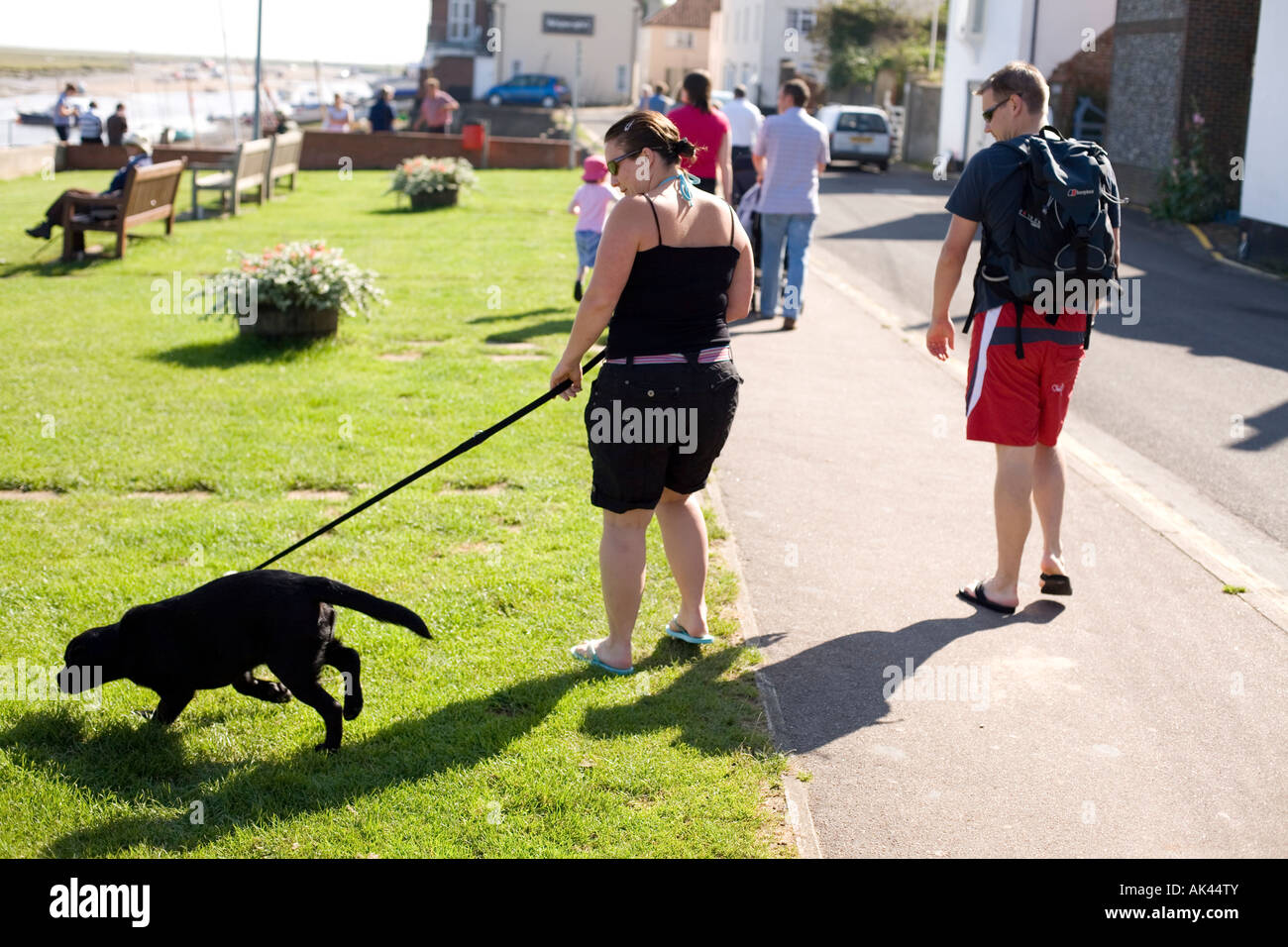Two people walk their dog Stock Photo - Alamy