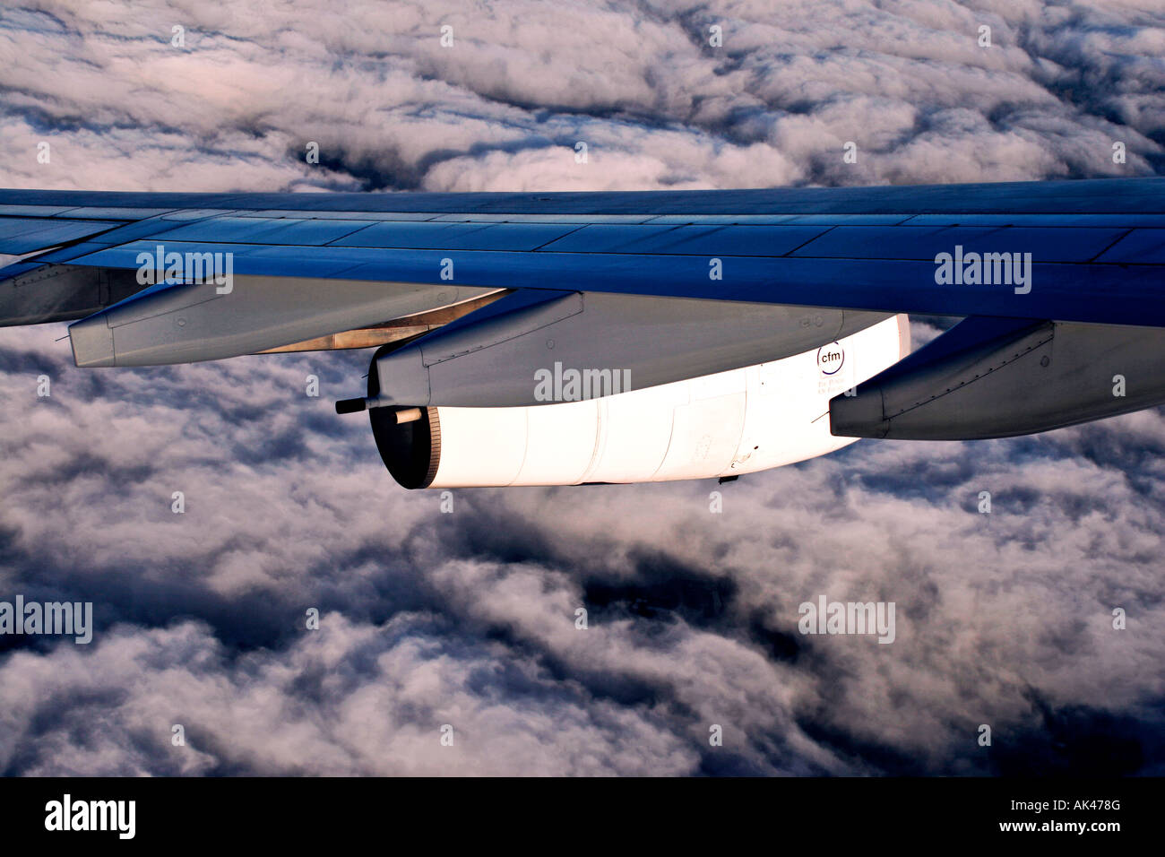 WIng and reactor of aircraft in flight with a background of clouds ...