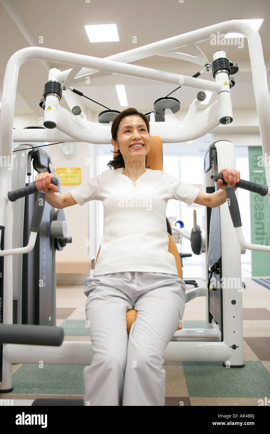Mature woman on exercise machine in gym Stock Photo - Alamy