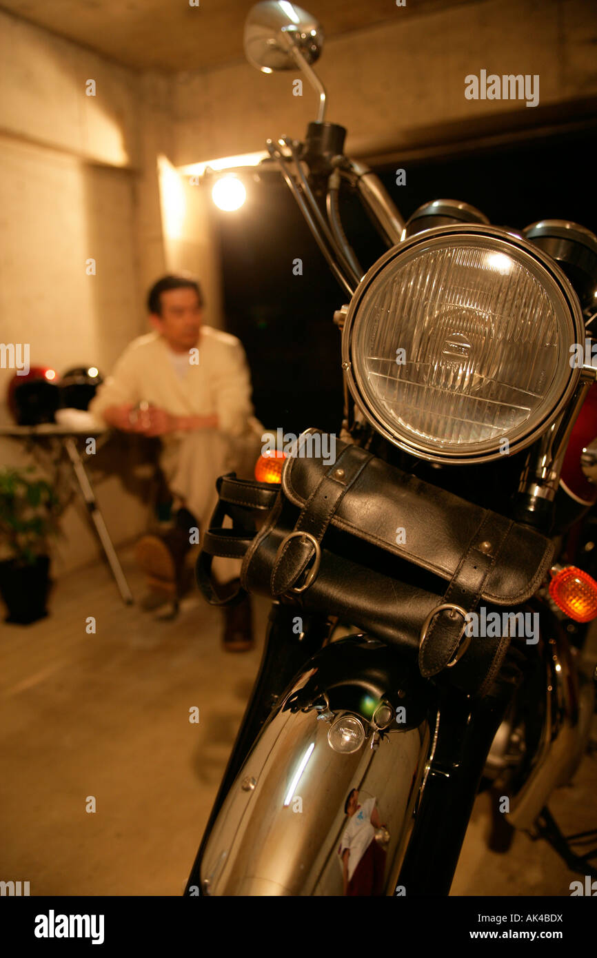 Mature man, in the background, looking at his motorcycle Stock Photo ...