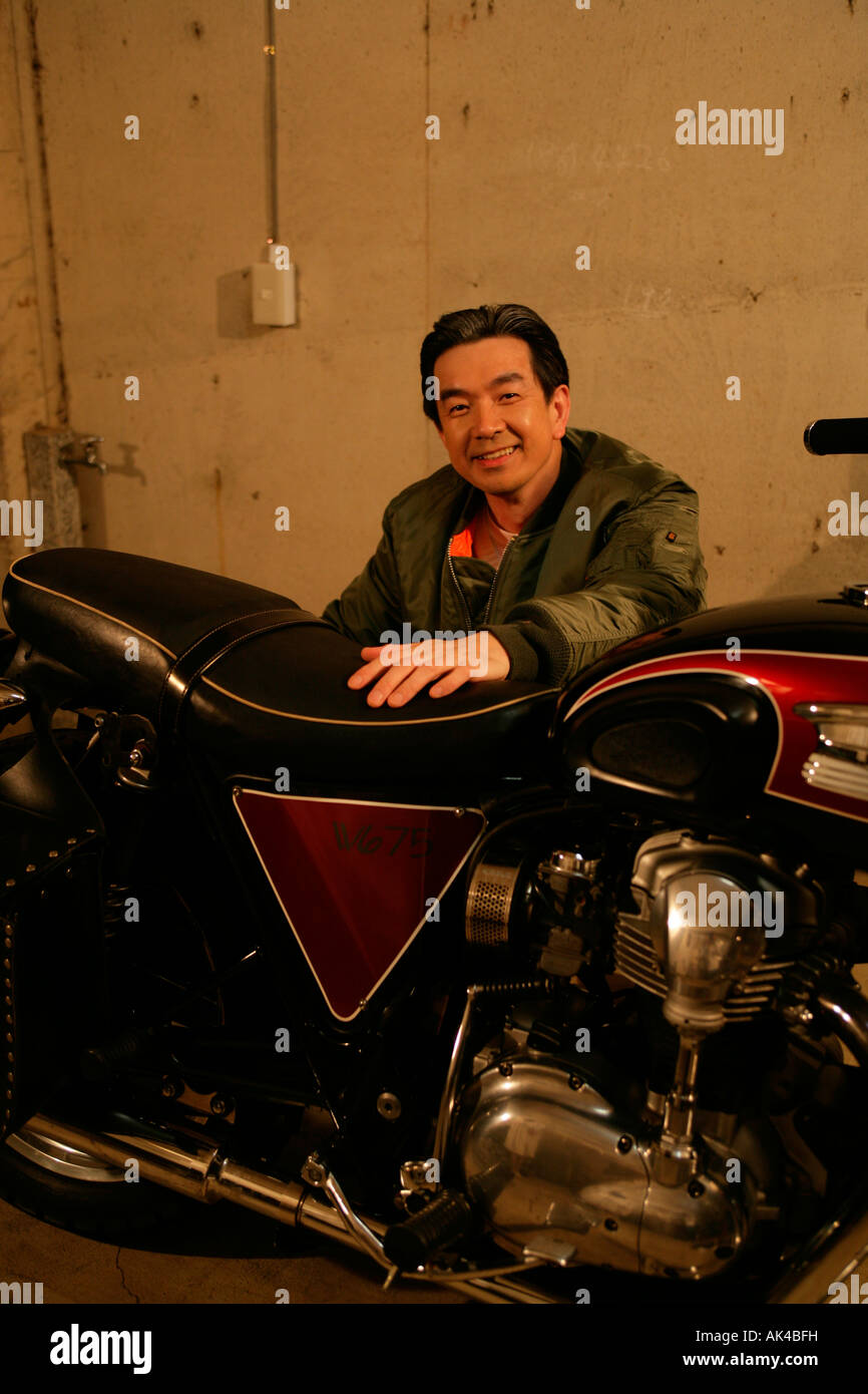 Mature man beside motorcycle, smiling Stock Photo - Alamy