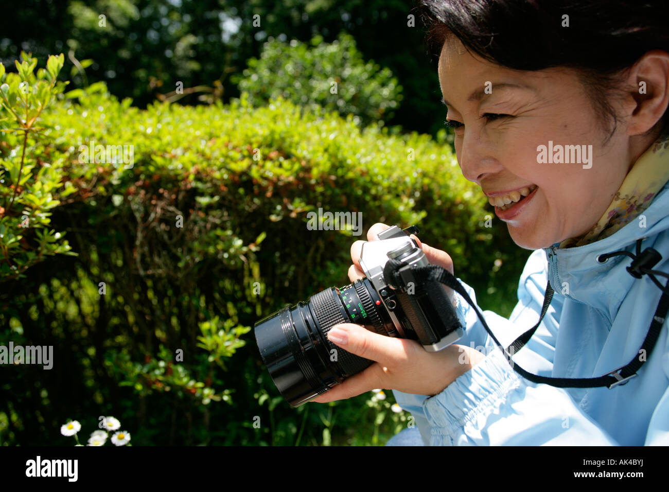 Mature woman holding camera Stock Photo - Alamy