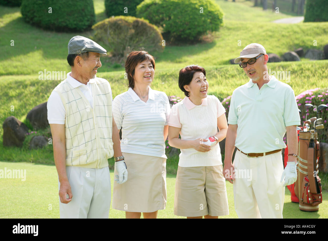 Four mature adults standing at golf course Stock Photo - Alamy