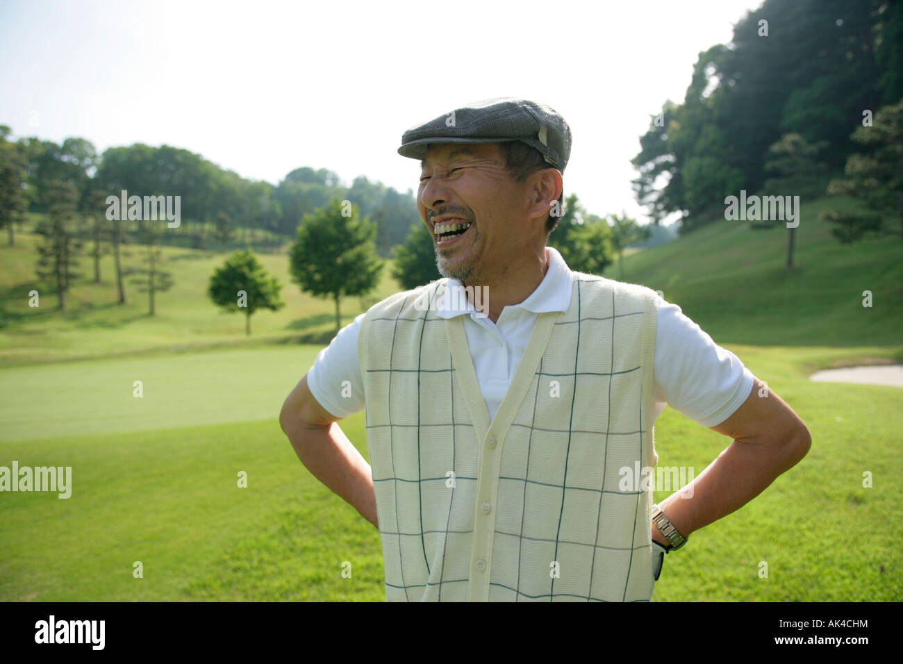 Man standing on golf course, laughing Stock Photo - Alamy