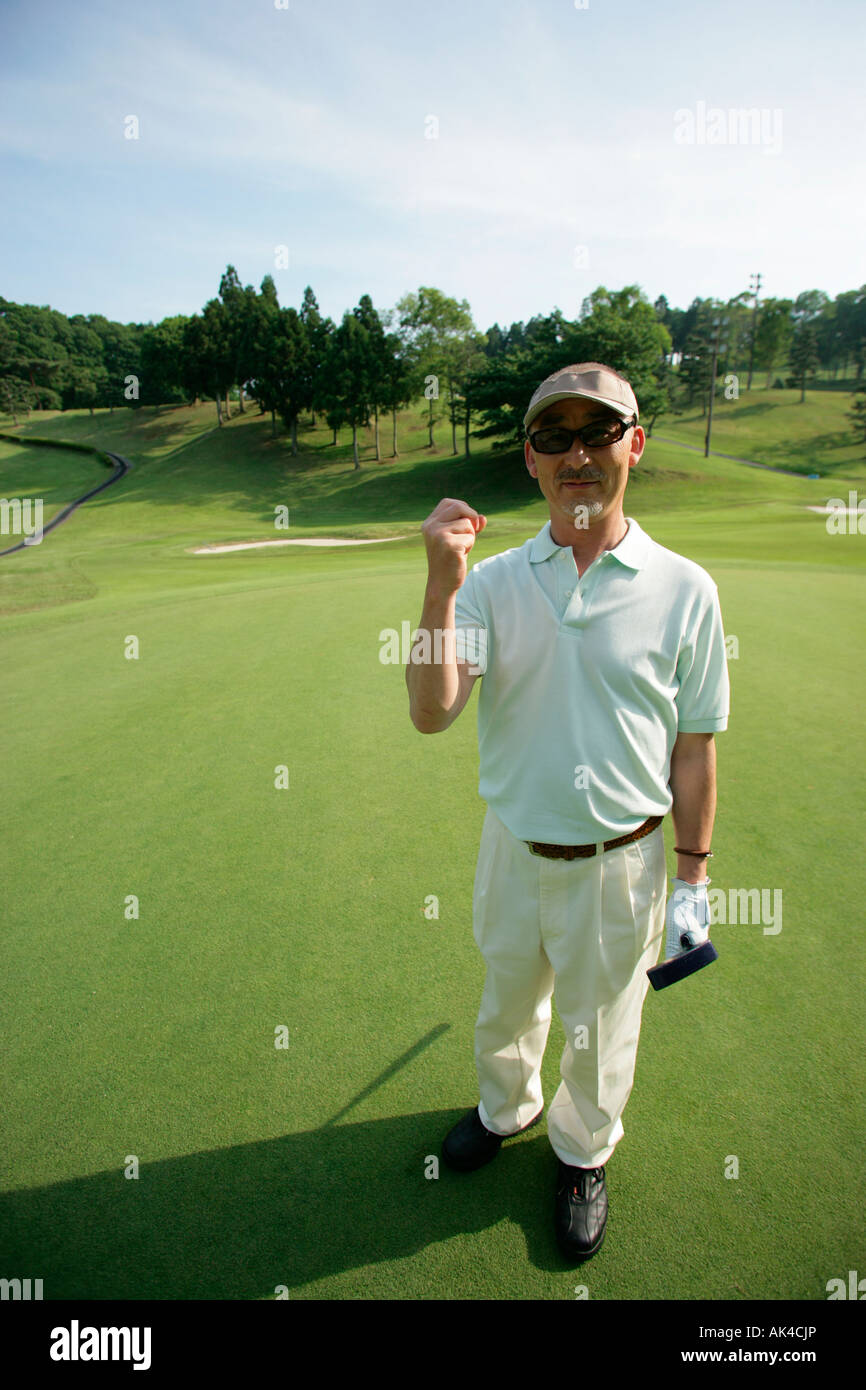 Man standing on golf course, holding a golf club Stock Photo - Alamy