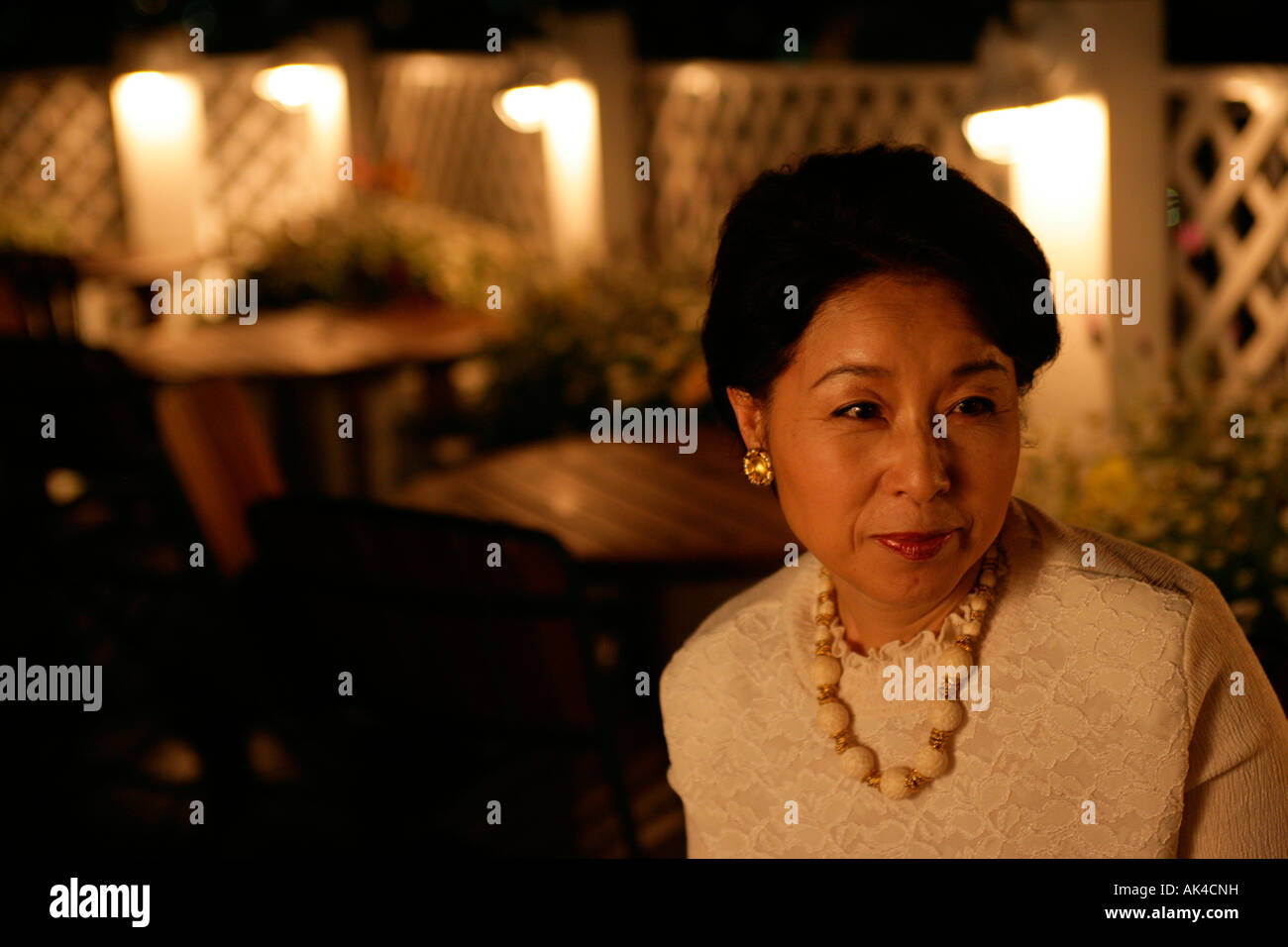 Woman sitting at dinner table, smiling Stock Photo - Alamy