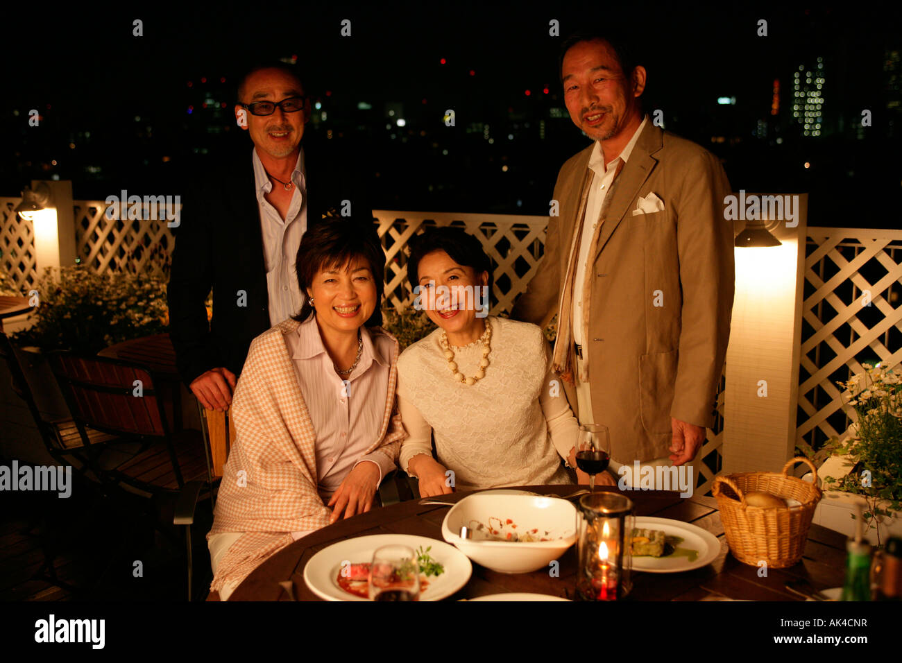 Four adults relaxing over dinner Stock Photo - Alamy