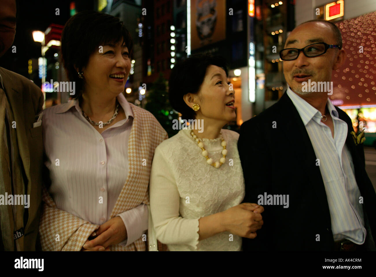 Two couples walking on the street at night, close-up Stock Photo - Alamy