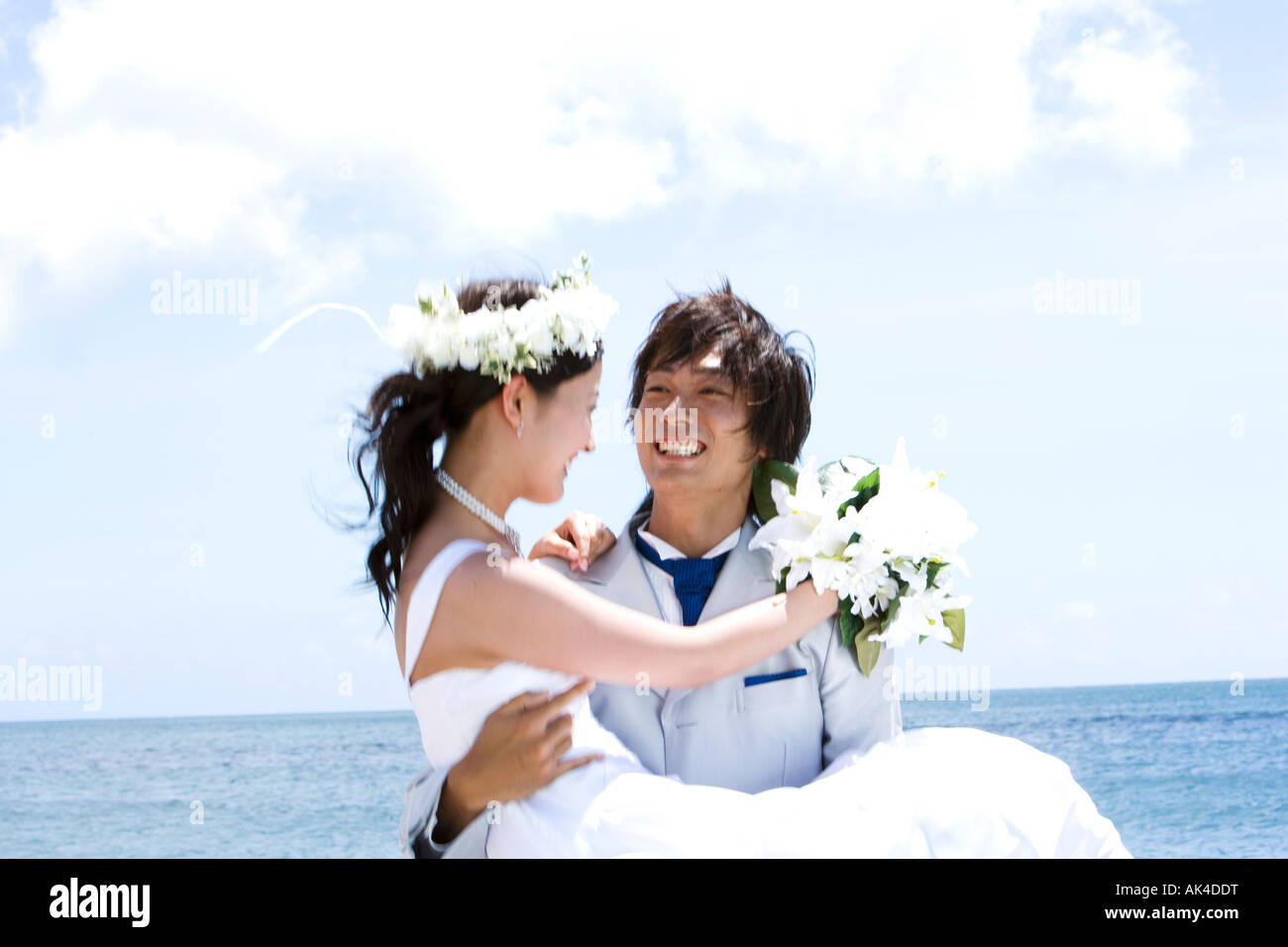 Bridegroom carrying bride at the beach Stock Photo - Alamy