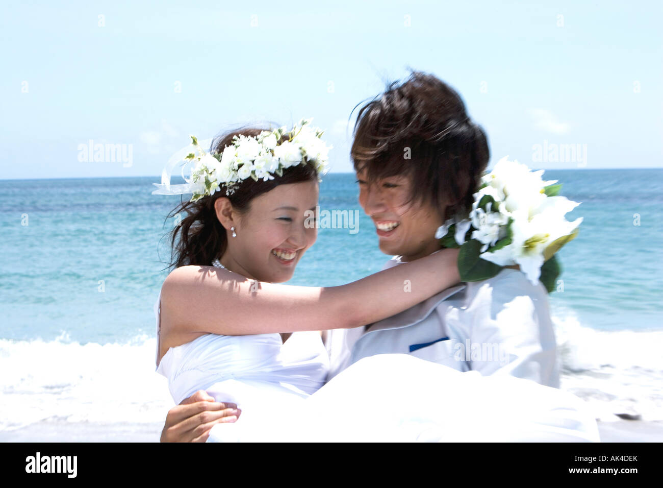 Bridegroom carrying bride at the beach Stock Photo - Alamy