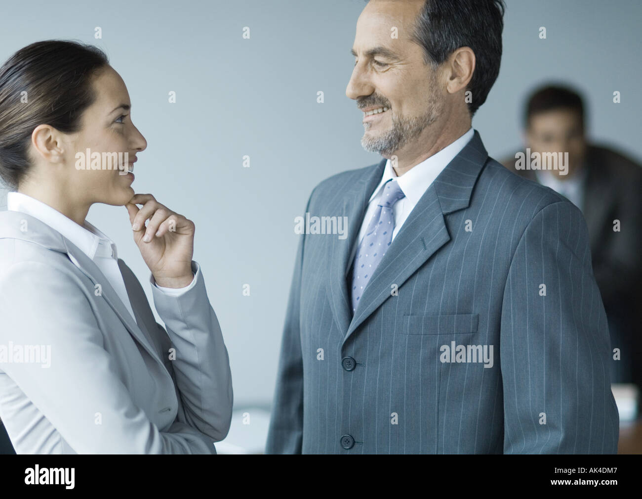 Business colleagues standing face to face, smiling Stock Photo - Alamy
