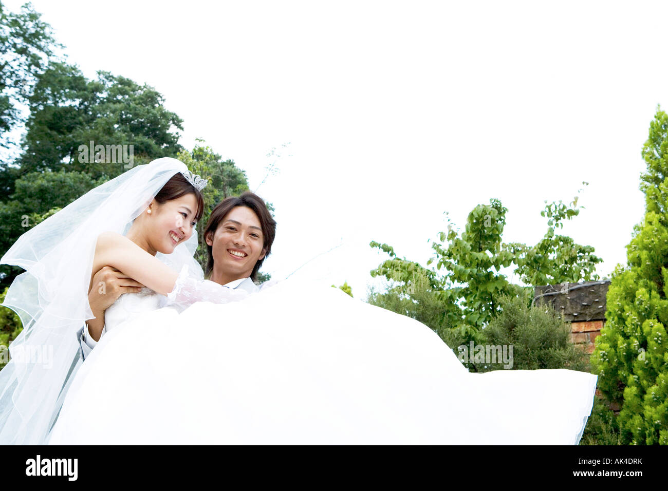 Bridegroom carrying bride in garden Stock Photo - Alamy