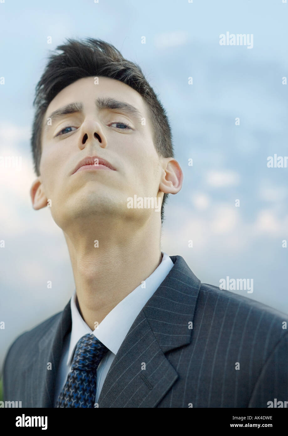 Young businessman, looking down at camera, portrait Stock Photo - Alamy