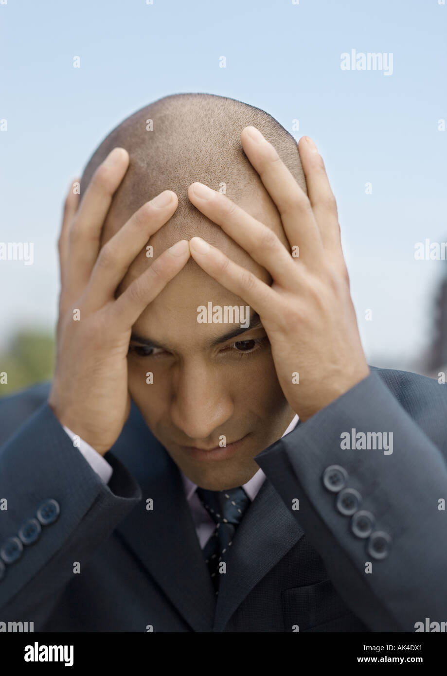 Businessman holding head Stock Photo - Alamy