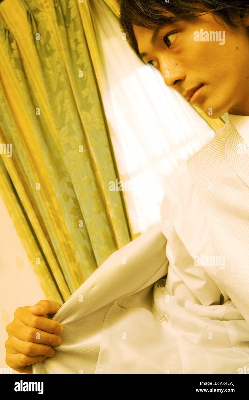 Young man putting on jacket, close-up Stock Photo - Alamy