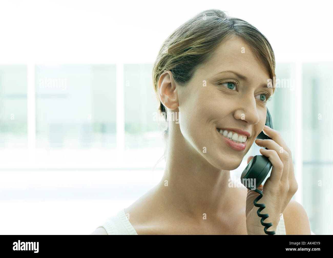 Woman using telephone, smiling Stock Photo - Alamy
