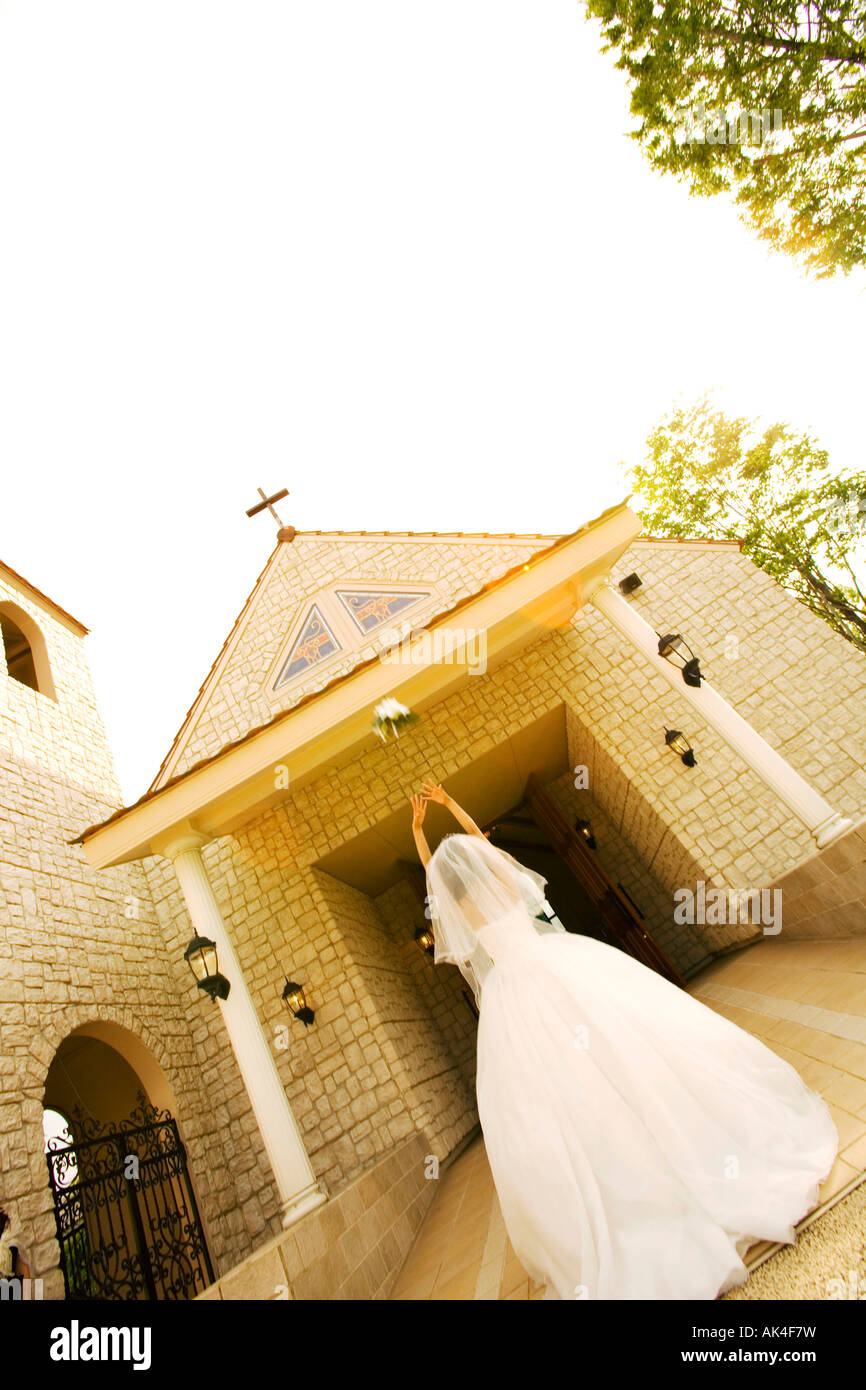 Bride throwing bouquet of flower into the air, rear view Stock Photo ...